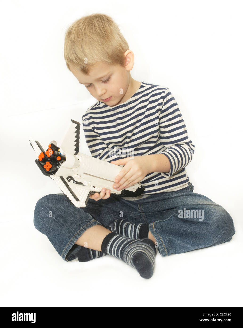Child blond boy playing with Lego Space Shuttle model toy cut out Stock ...