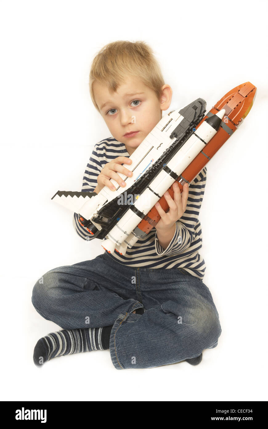 Child blond boy playing with Lego Space Shuttle model toy cut out Stock ...