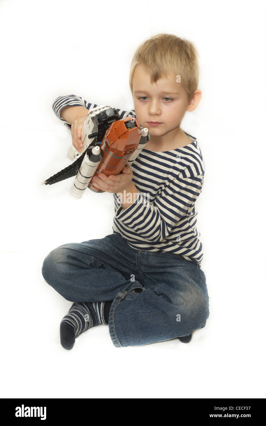 Child blond boy playing with Lego Space Shuttle model toy cut out Stock ...