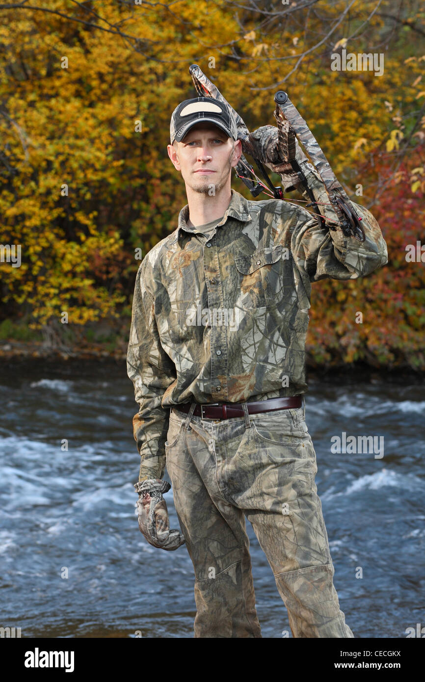 handsome bow hunter by a fall stream Stock Photo - Alamy