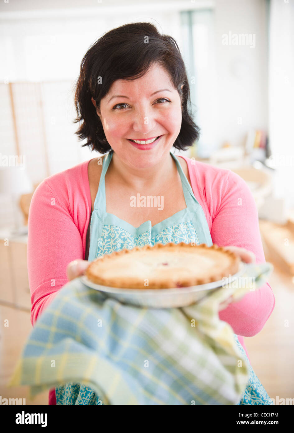 Hispanic woman holding out homemade pie Stock Photo - Alamy