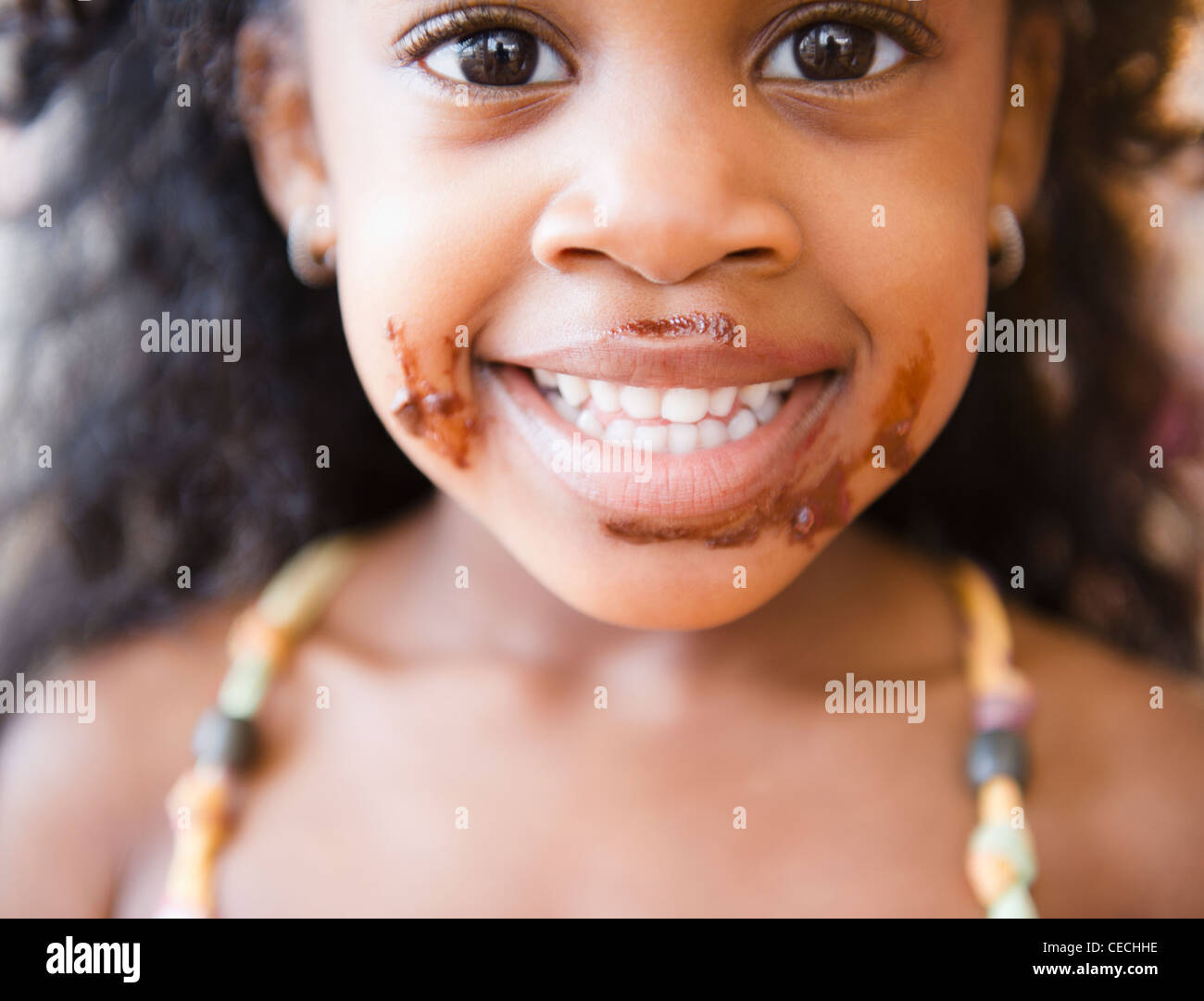 Mixed race girl with chocolate on her face Stock Photo - Alamy