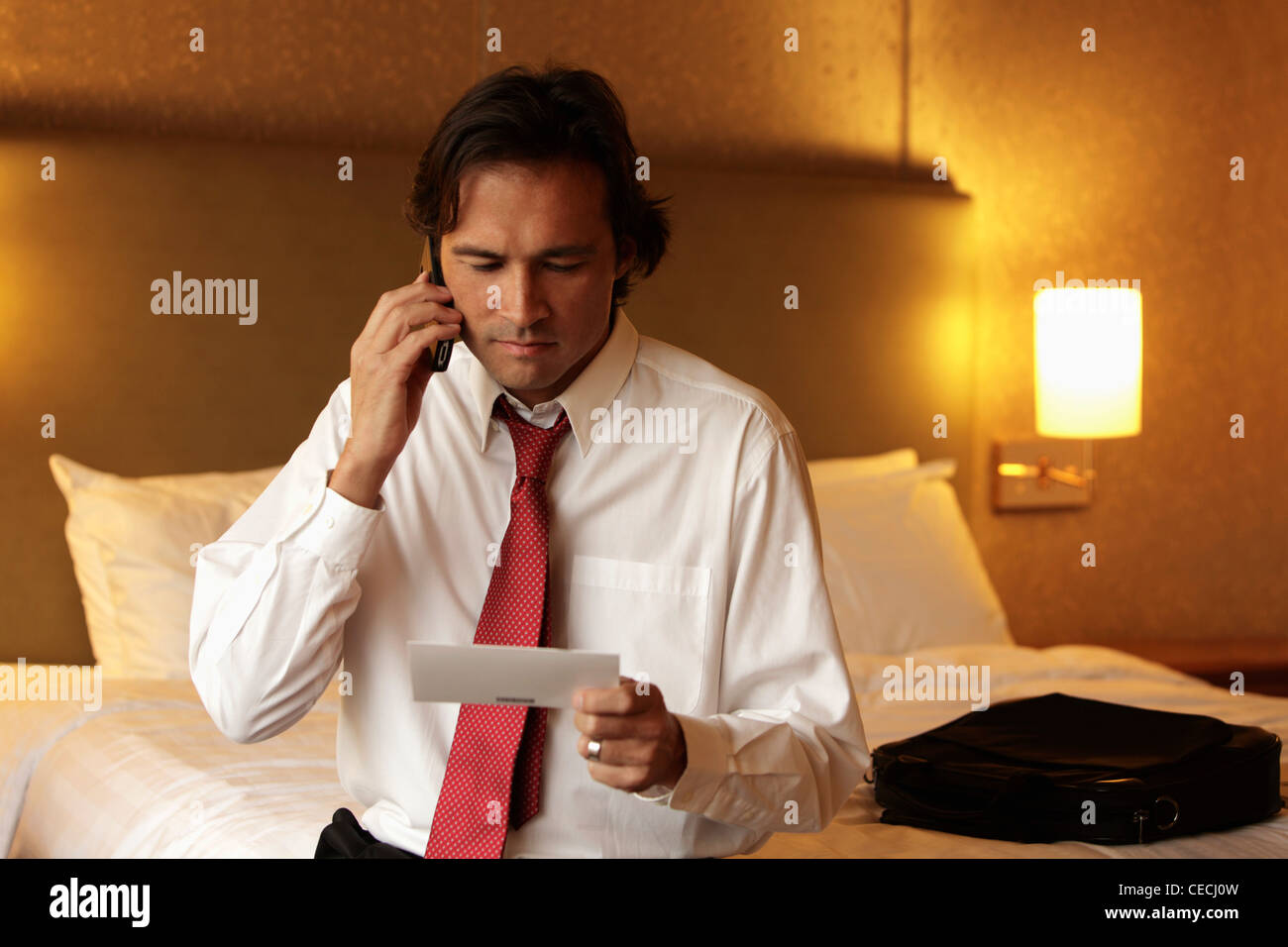 Man holding ticket and phone and frowning Stock Photo - Alamy