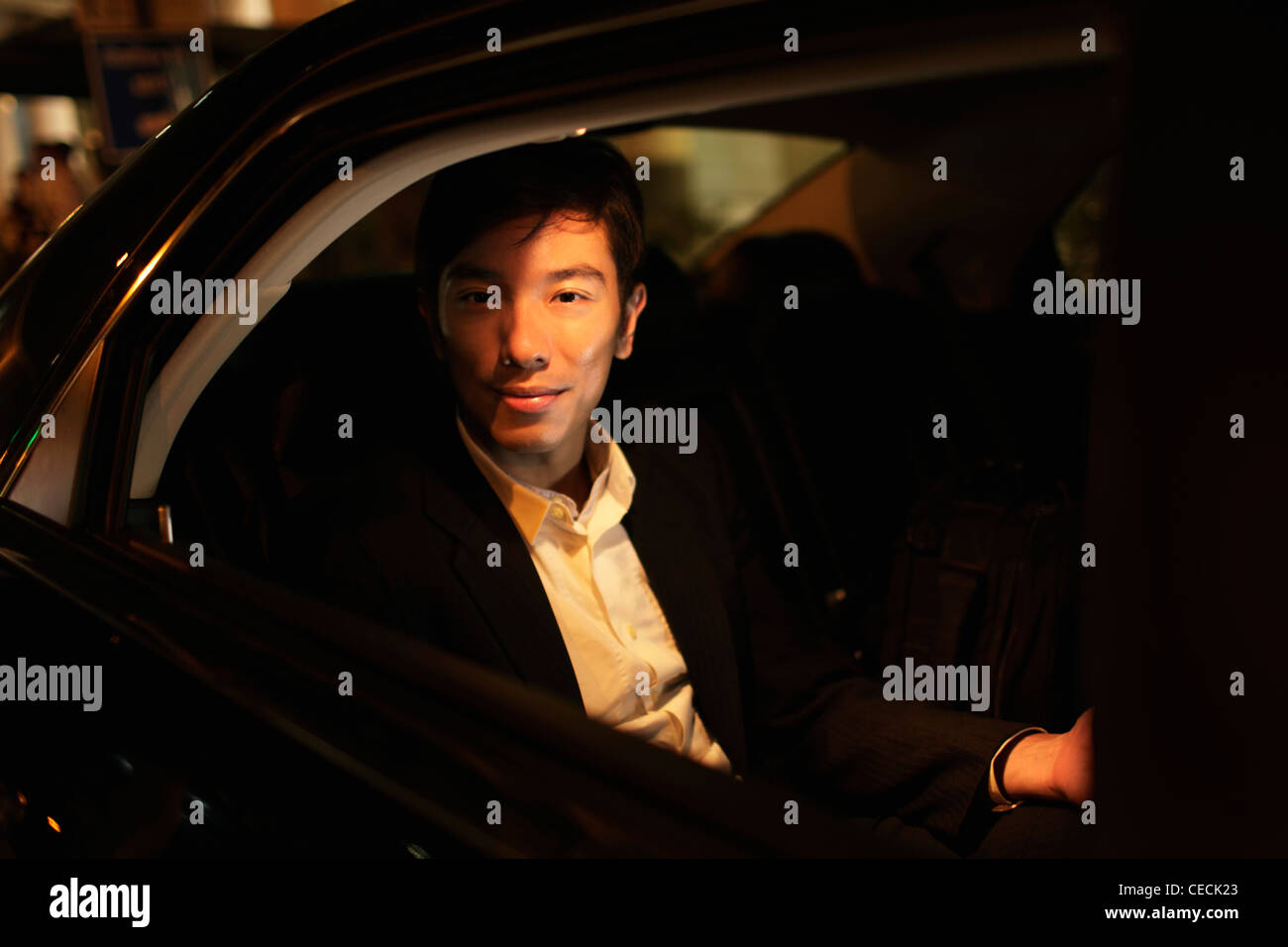 Young man sitting in car looking out of window at night Stock Photo - Alamy