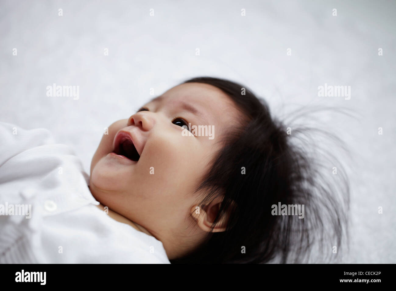Chinese baby laying on back smiling Stock Photo - Alamy