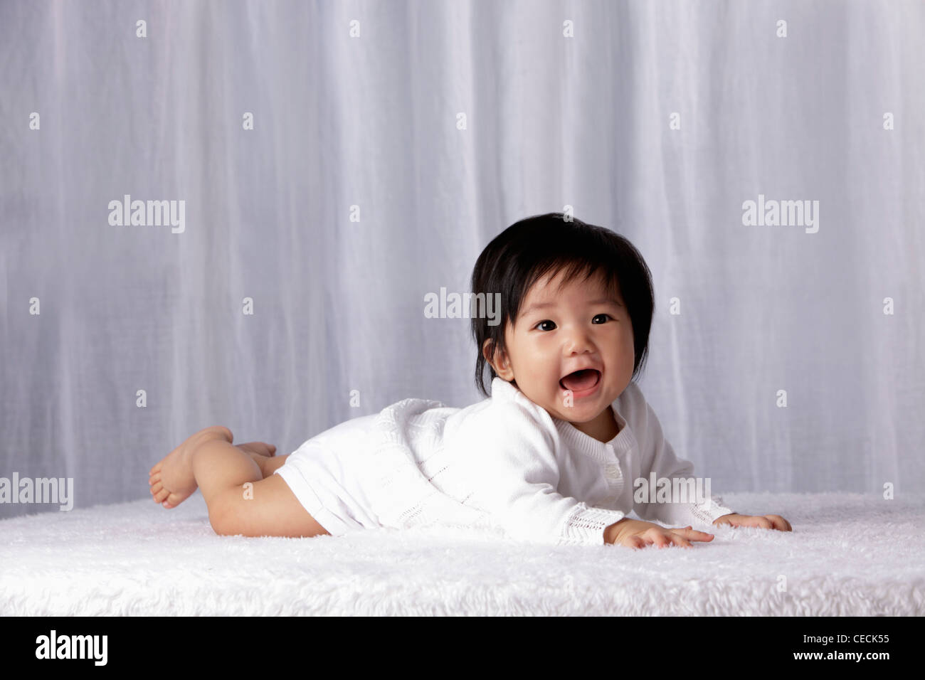 Chinese baby on tummy smiling Stock Photo - Alamy
