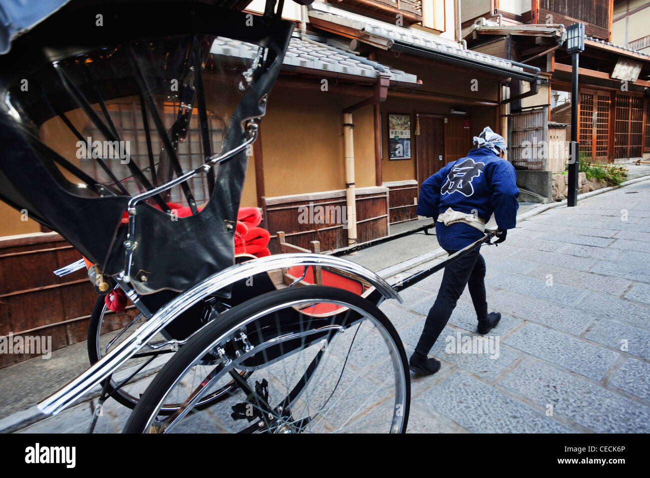 man pulling rickshaw in front of houses. Japan,Kyoto Stock Photo - Alamy