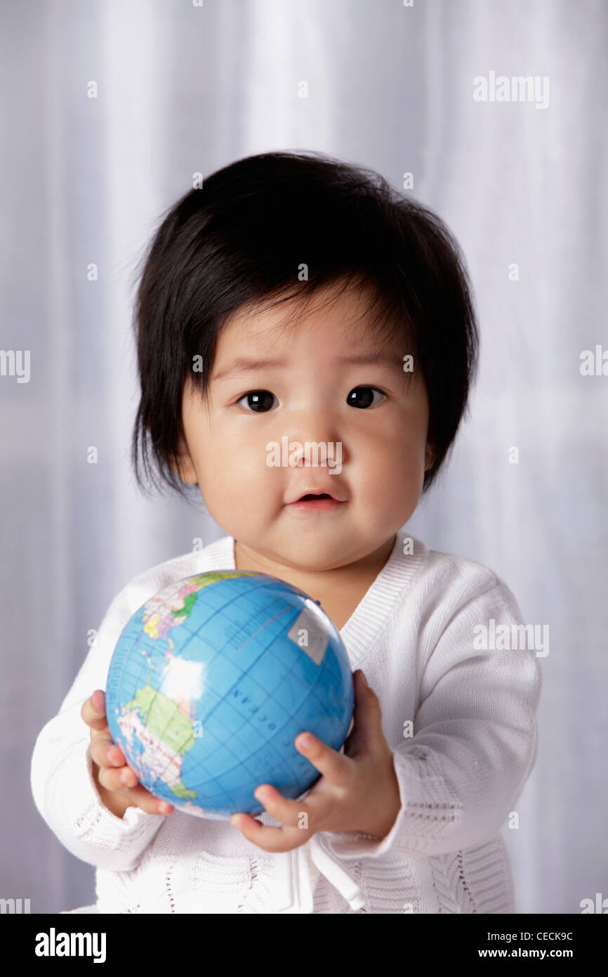 Head shot of Chinese baby holding small globe Stock Photo - Alamy