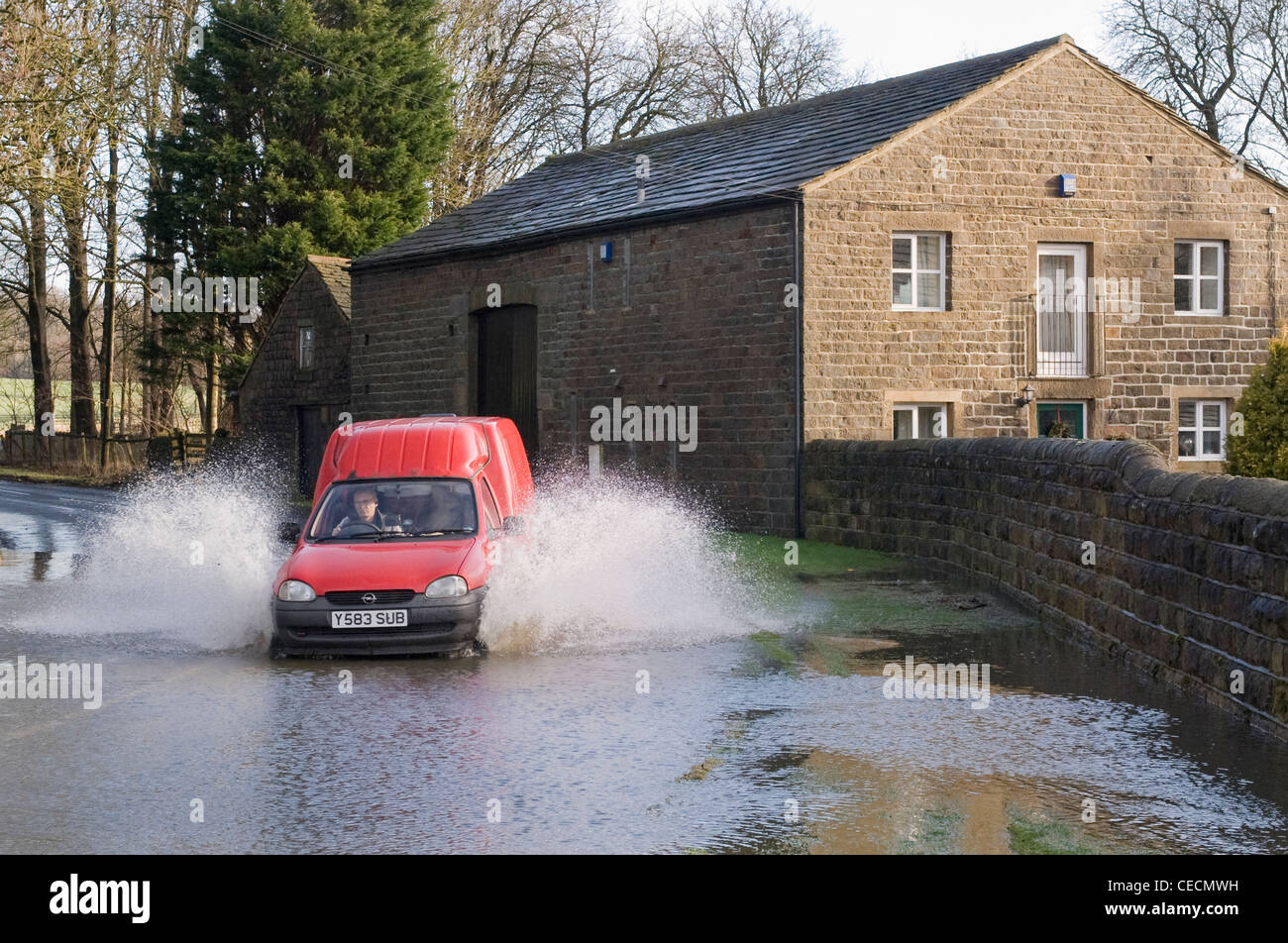 Flooding- man driving red van, splashing through deep flood water on ...
