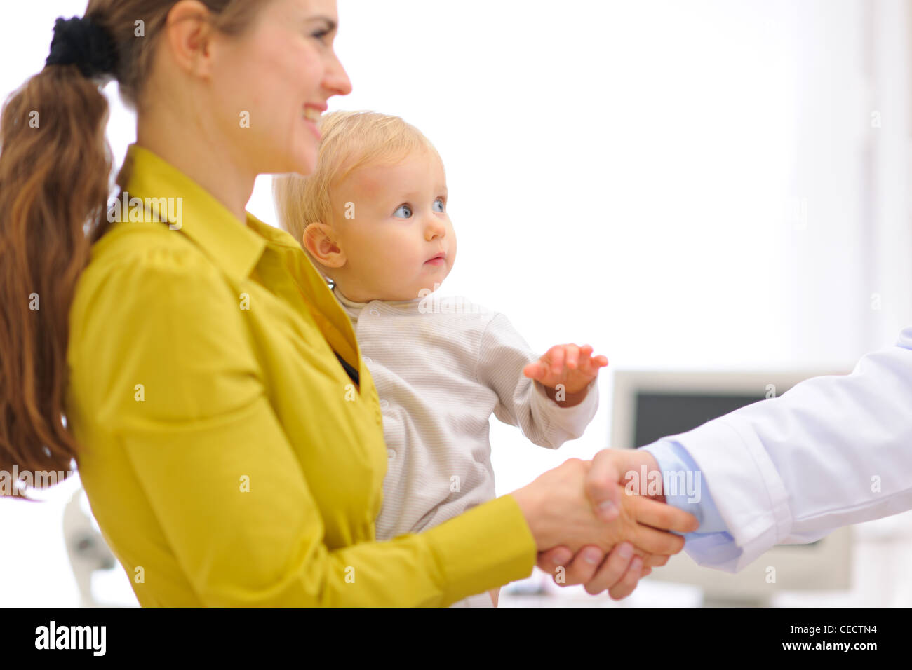 Closeup on mother with baby thanking pediatrician doctor for ...