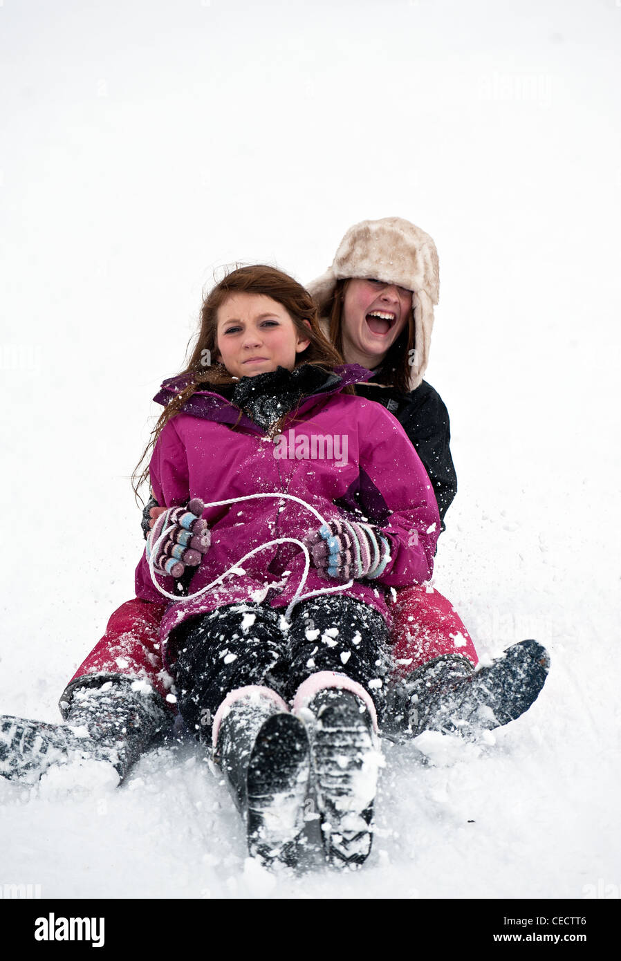Two girls sledding Stock Photo - Alamy