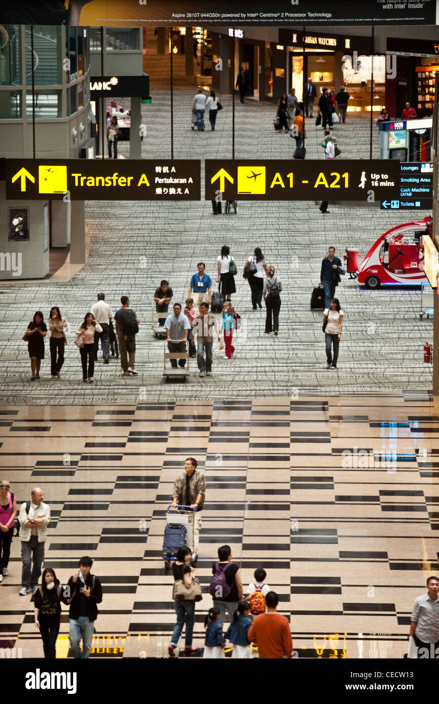 Passengers walk through the transit hall in terminal 3 at Changi ...