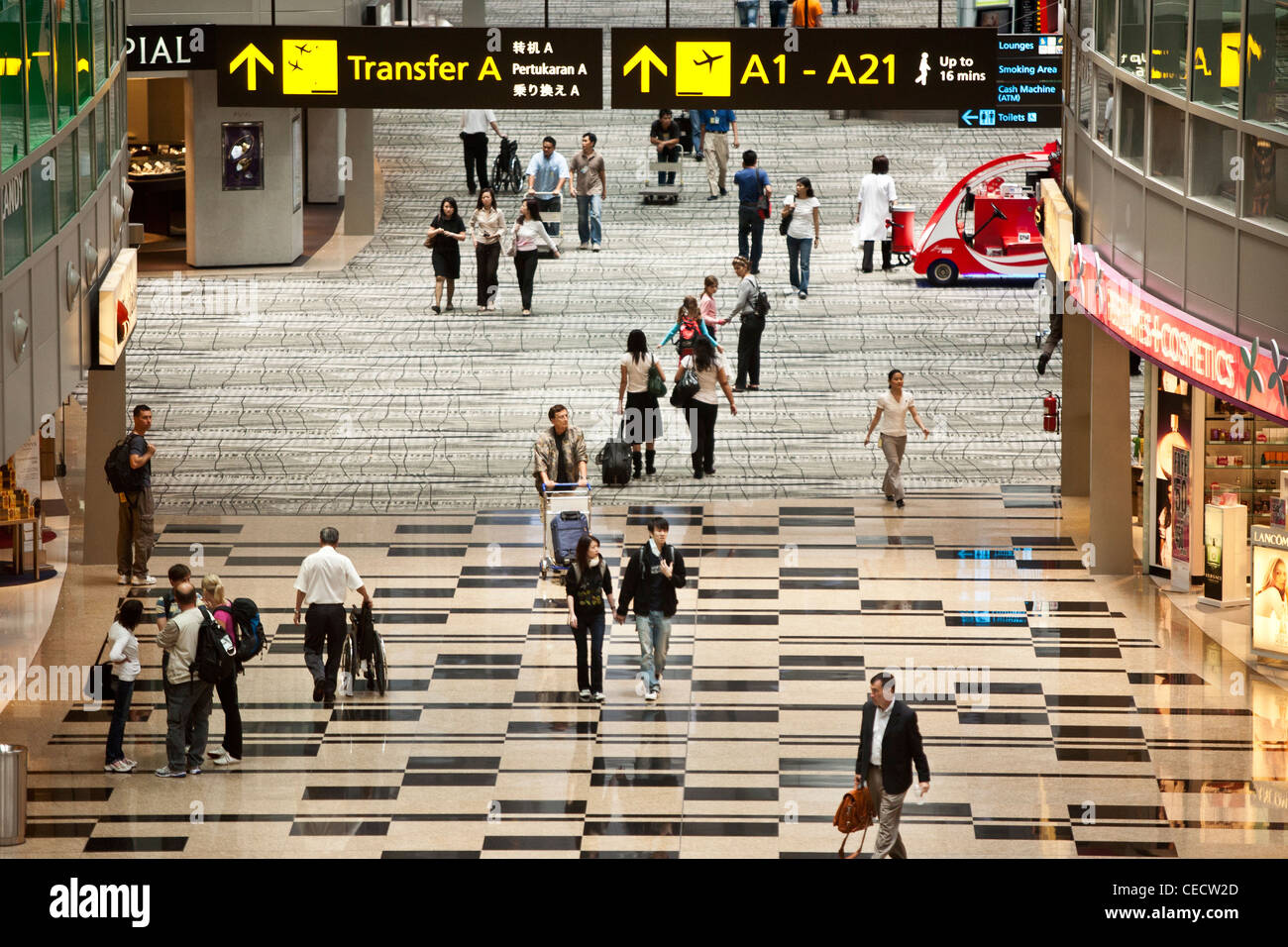 Passengers walk through the transit hall in terminal 3 at Changi ...