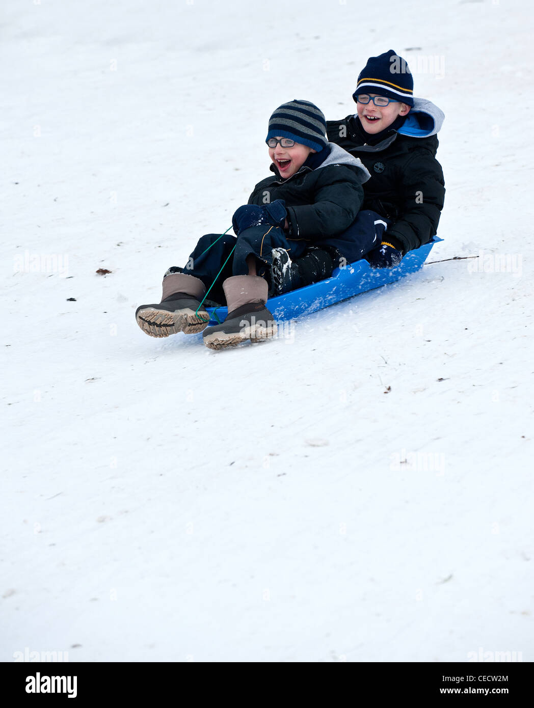 Two boys having fun sledding in the snow in Essex Stock Photo - Alamy