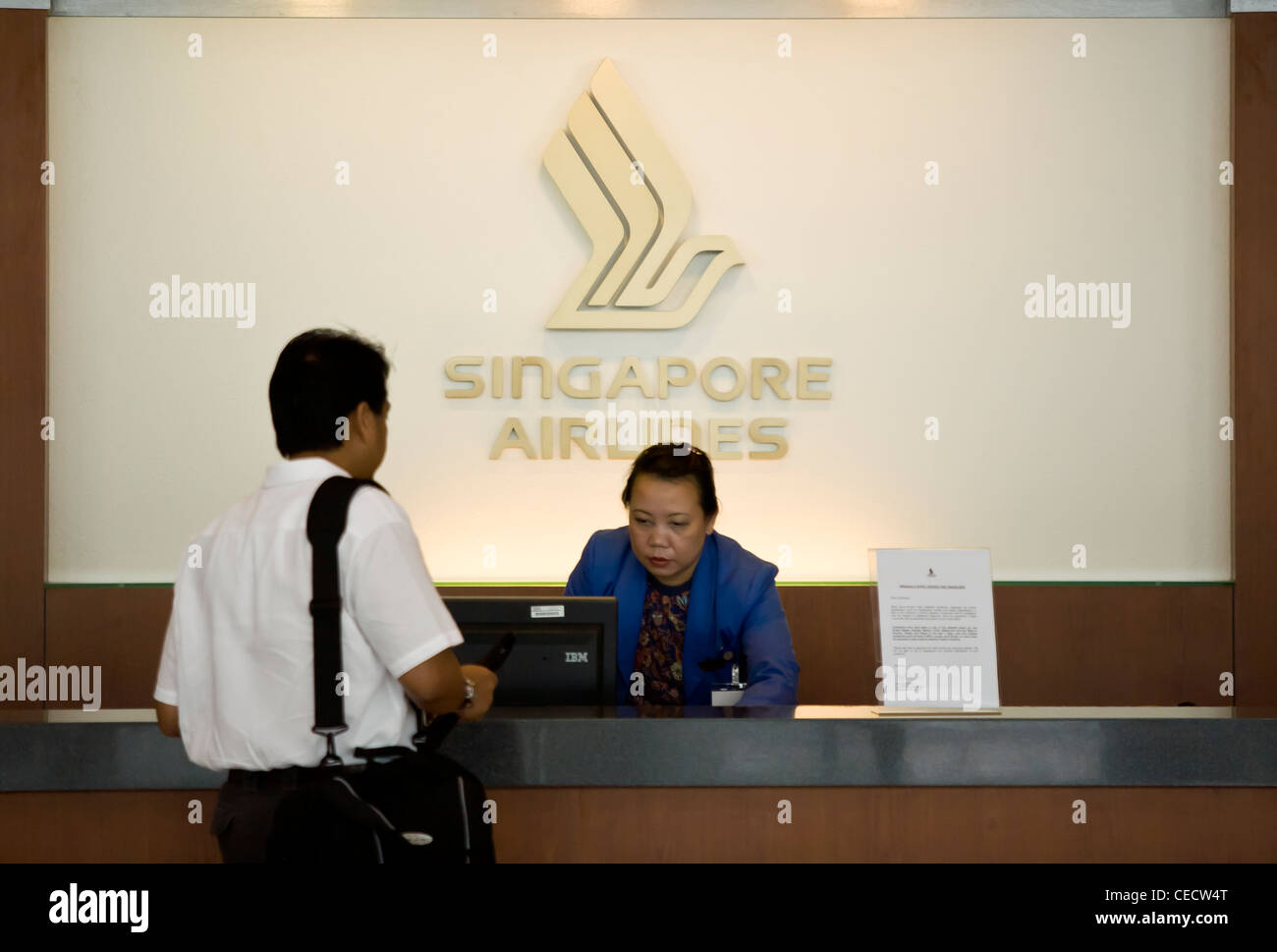 An employee helps a passenger at the Singapore Airlines Ltd ...