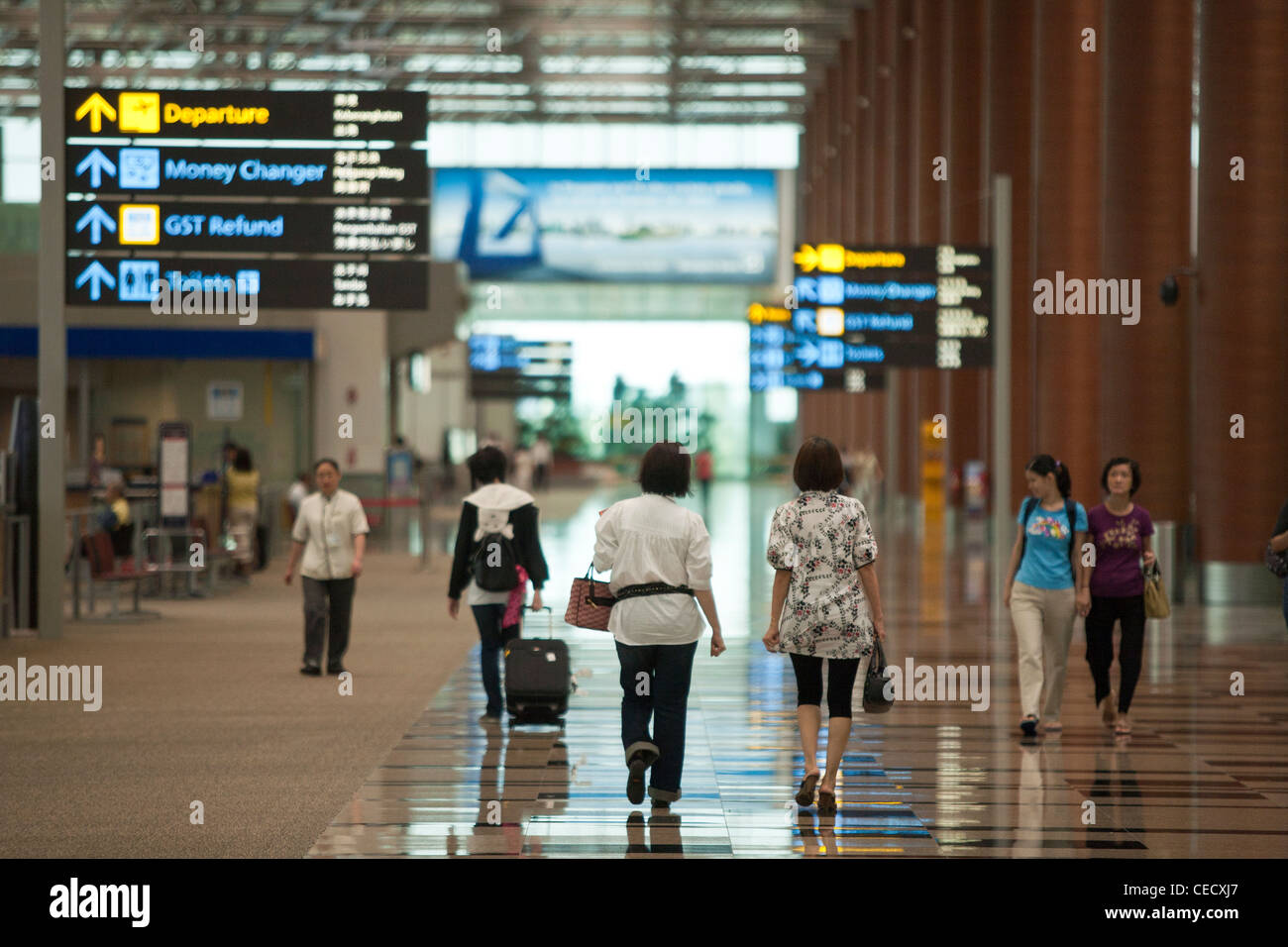 Passengers walk through the departures area of Terminal 3 at Changi ...