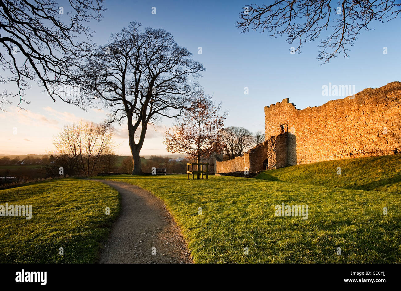 The setting sun illuminating the walls of Pickering castle on a winter ...