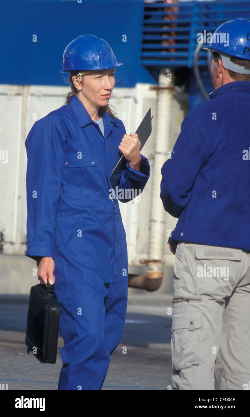 female marine engineer talking to workman Stock Photo - Alamy