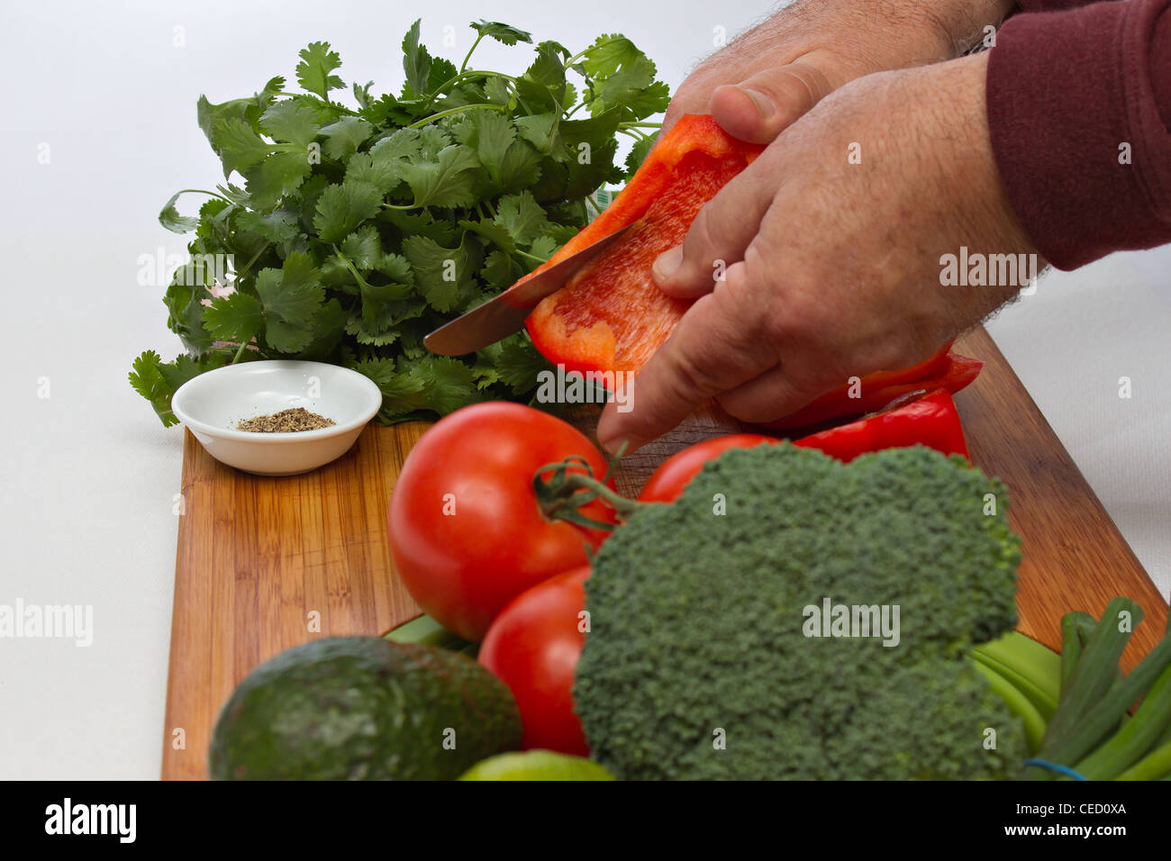 Hands of a cook preparing fresh vegetables for a meal. Included in ...
