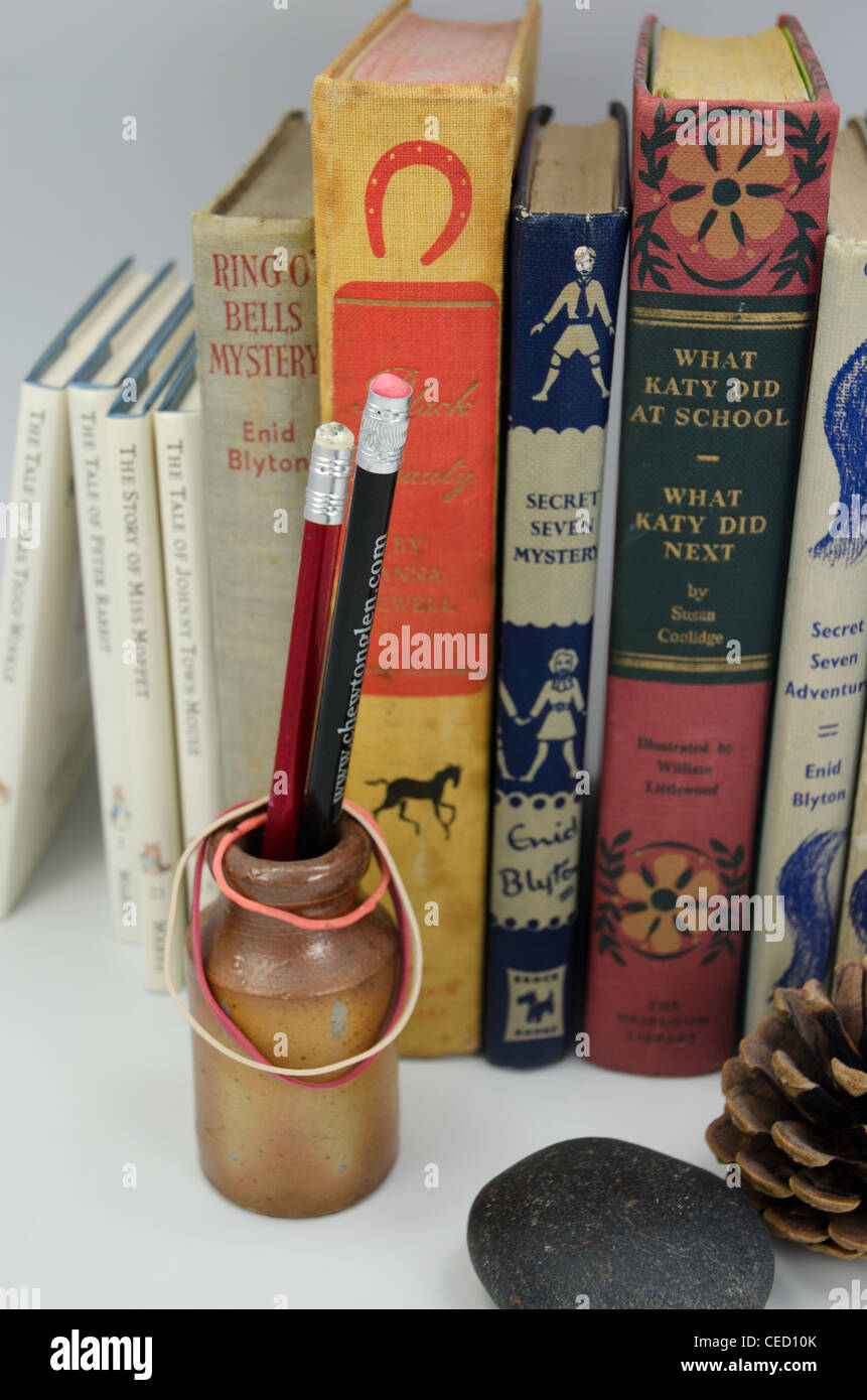 Vintage books with a vintage clay inkpot a pebble and a pine cone on a ...