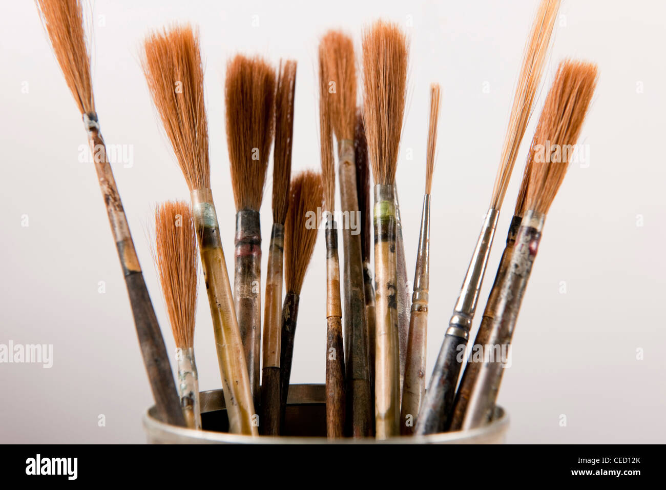 A collection of assorted fine paint brushes in an old tin can Stock ...