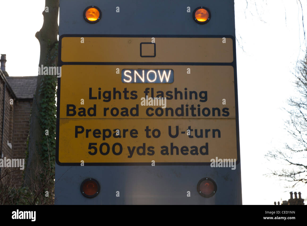 A flashing sign warns drivers of snow ahead Stock Photo - Alamy