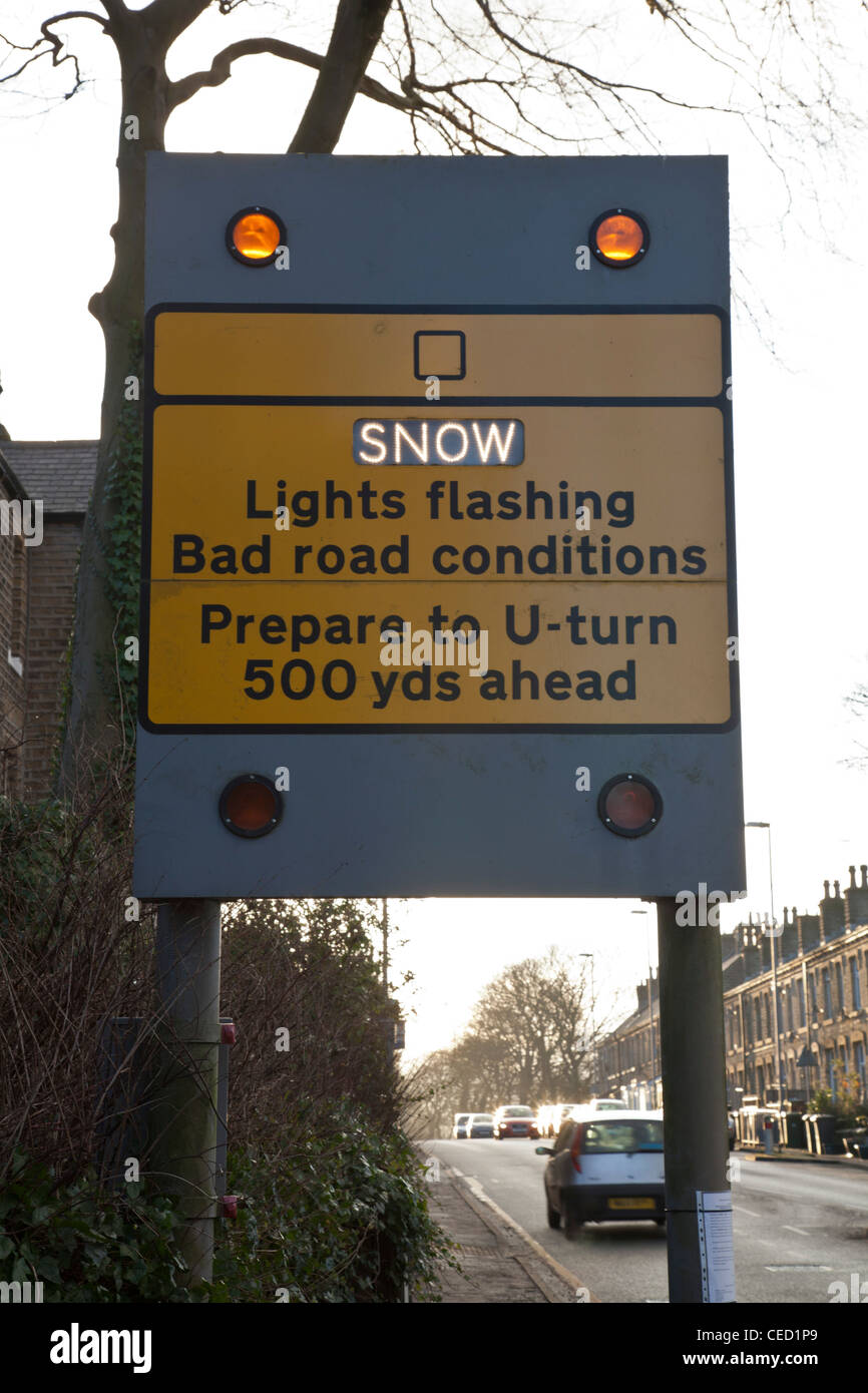 A flashing sign warns drivers of snow ahead Stock Photo - Alamy