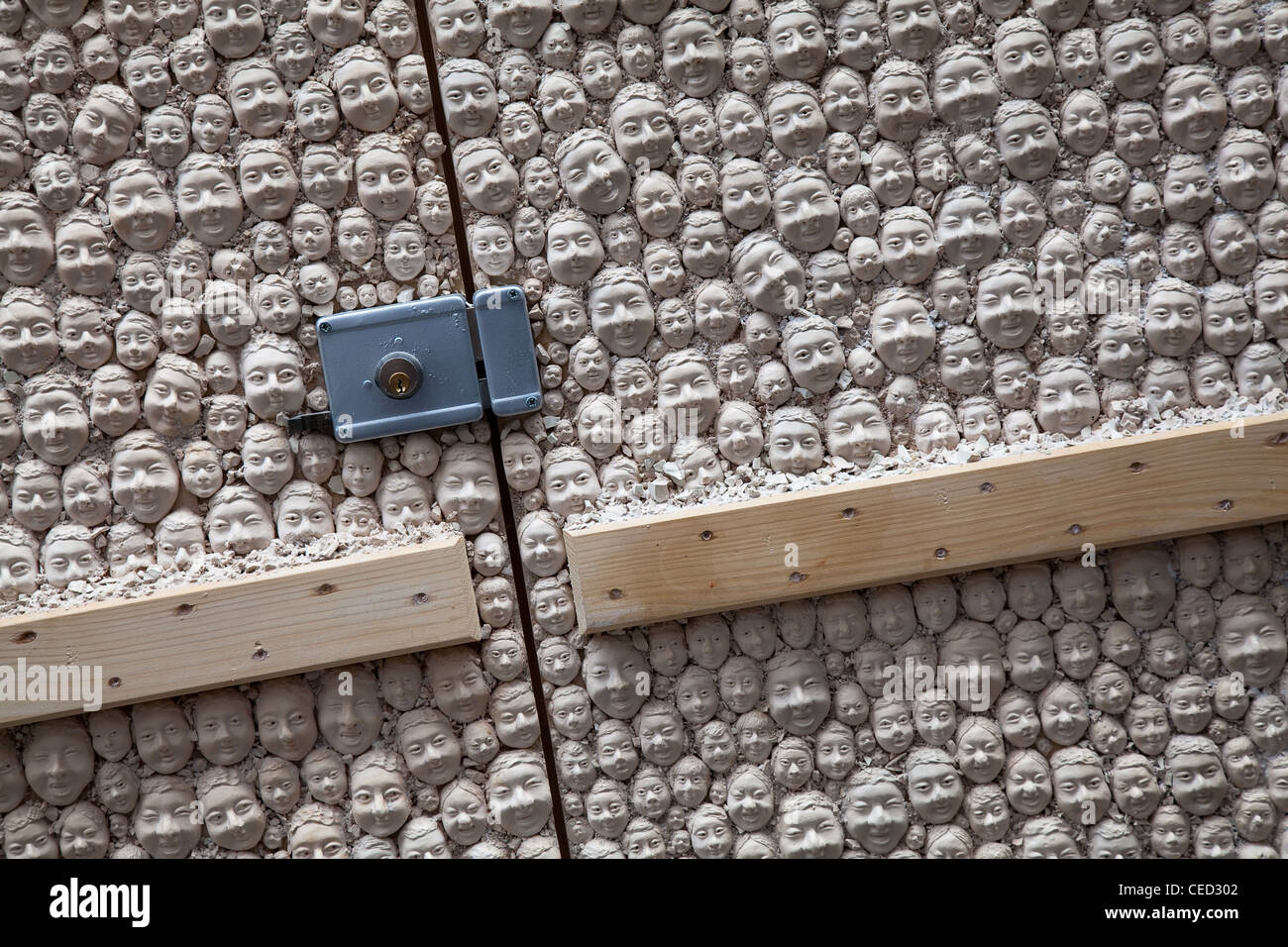 A modern door lock with plaster smiling heads & faces. Zona Histroica ...