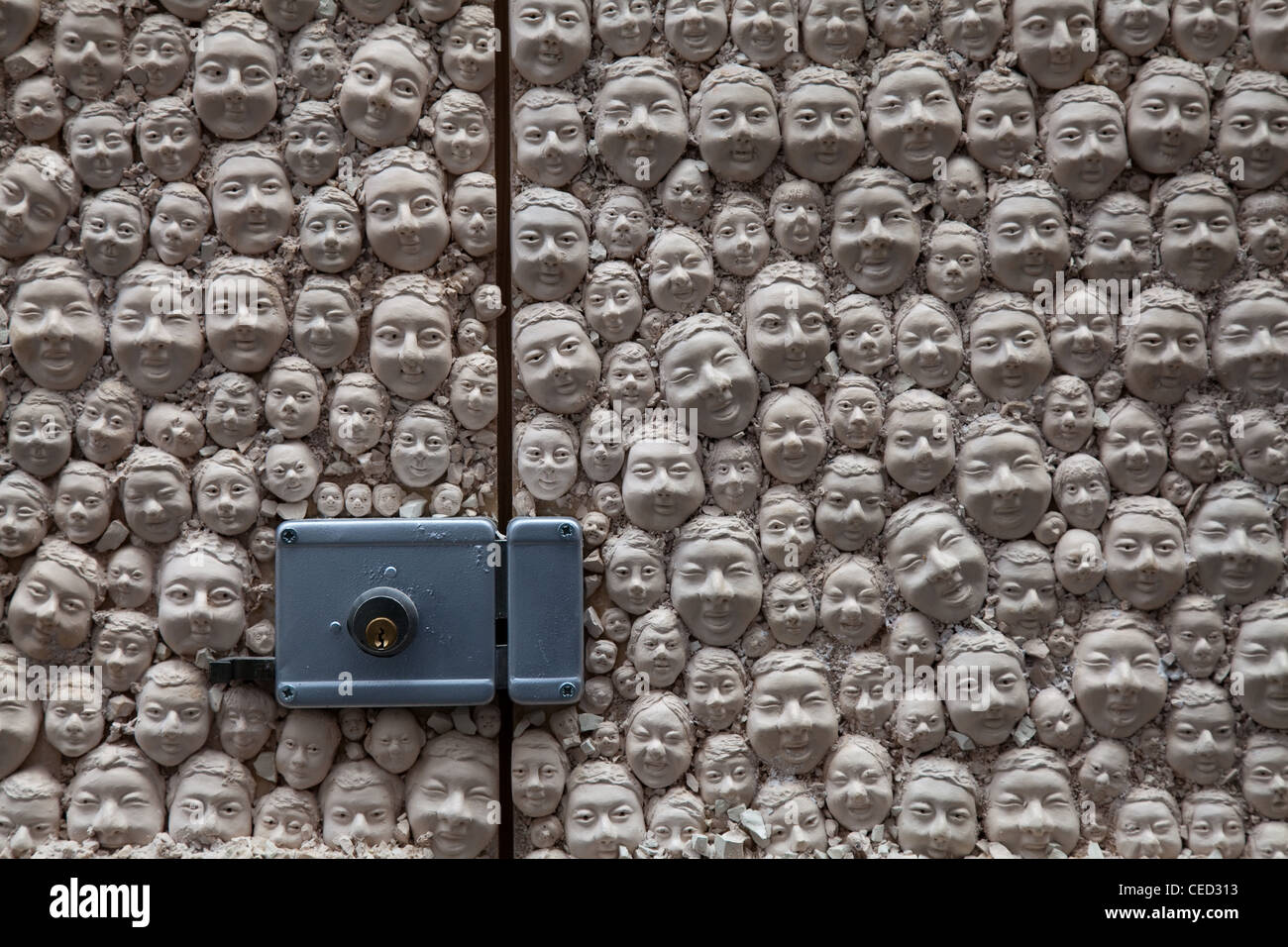 A modern door lock with plaster smiling heads & faces. Zona Histroica ...