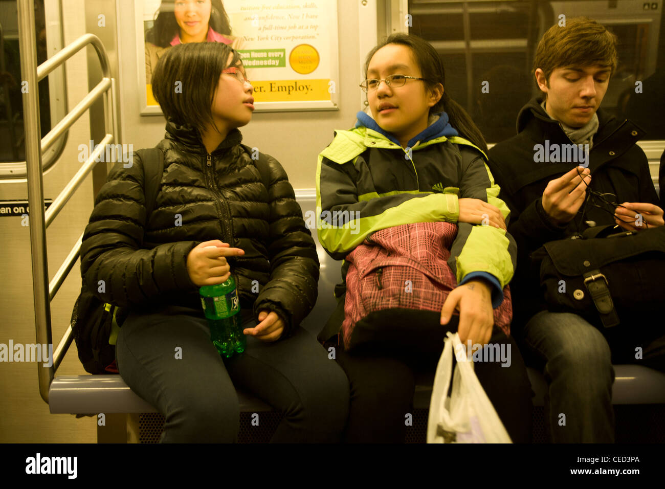 Asian American school girls riding the subway home from school ...