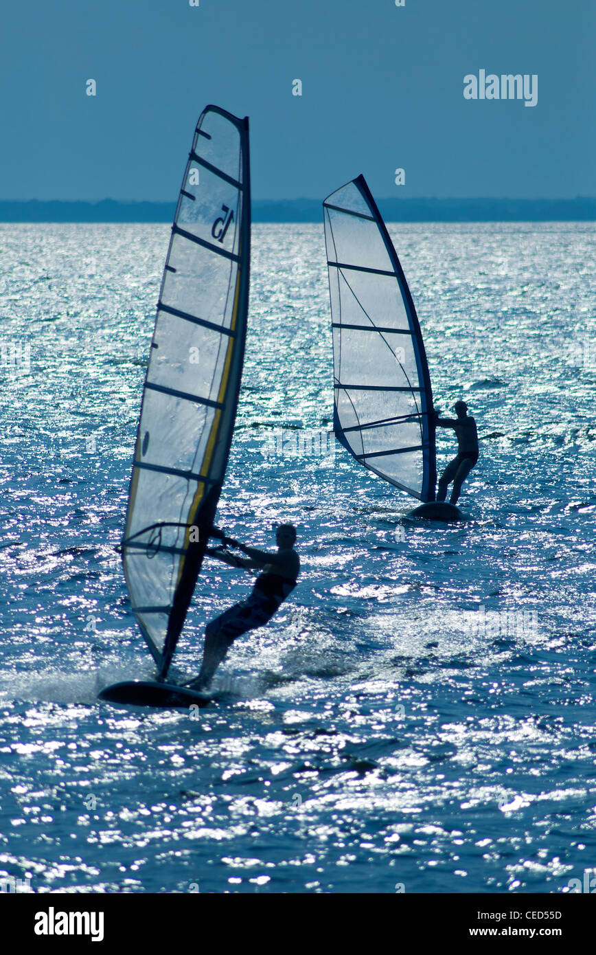 Two windsurfers in patches of light of a sunlight Stock Photo - Alamy