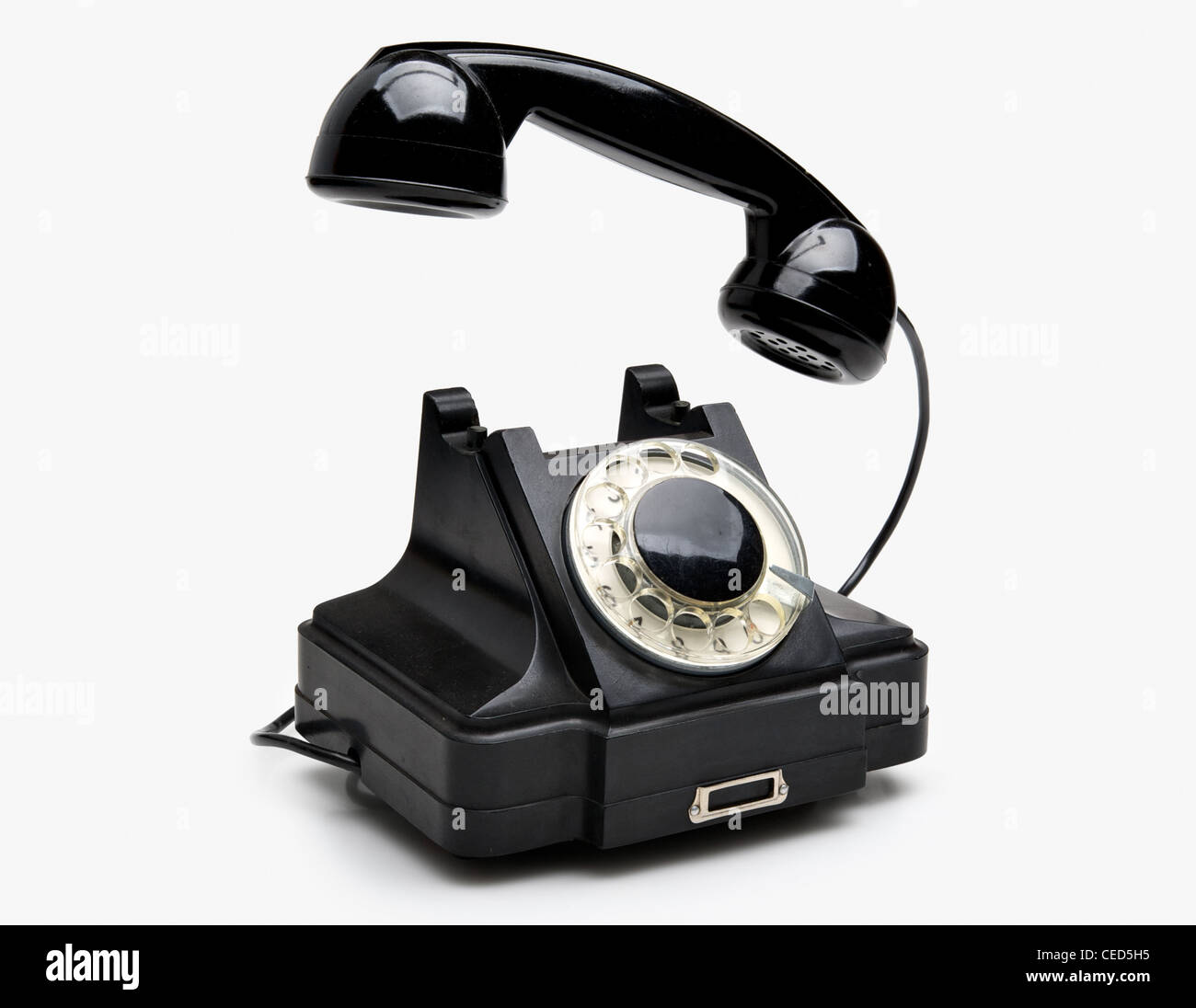 Old black vintage rotary style telephone isolated over a white ...
