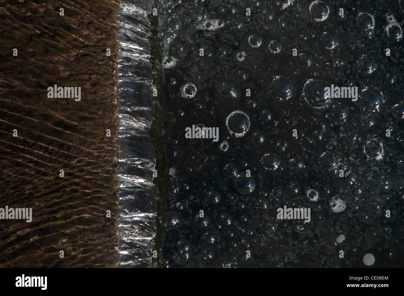 cascading water creating bubbles as small waterfall Stock Photo - Alamy