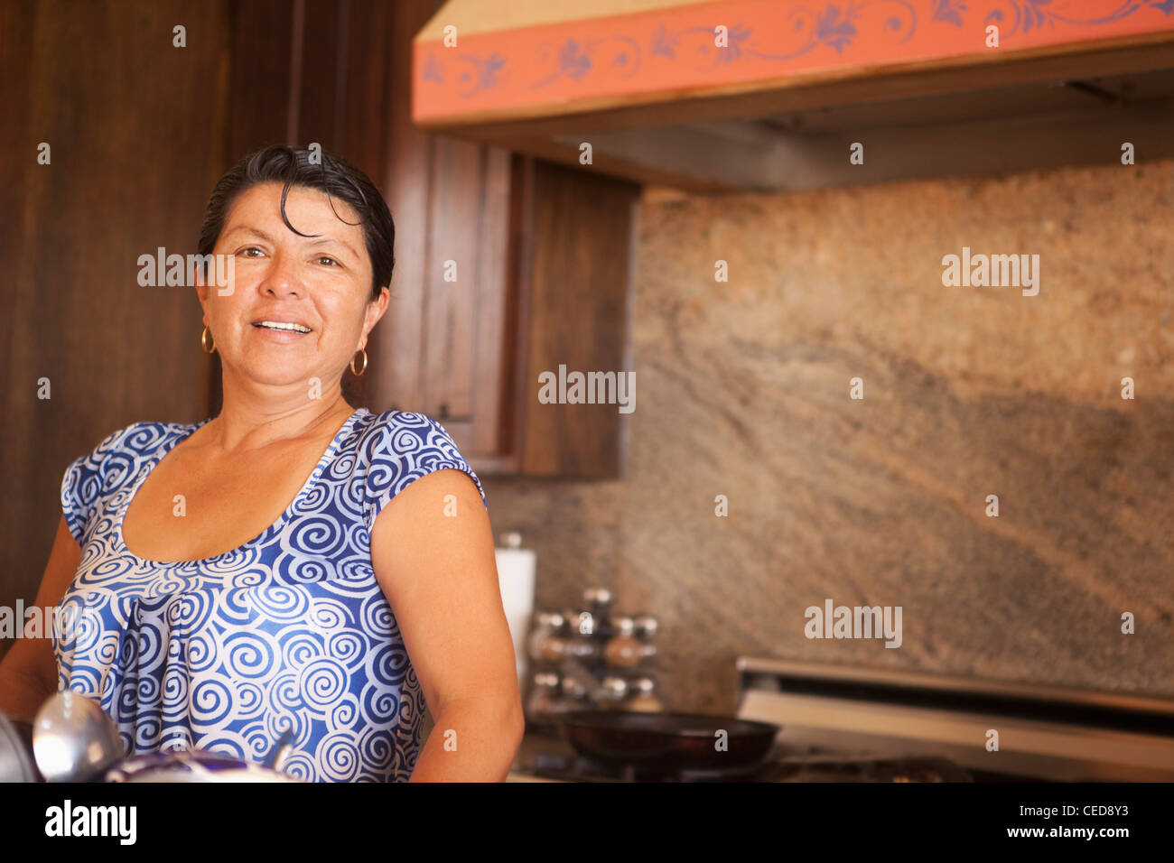 Hispanic woman standing in kitchen Stock Photo - Alamy