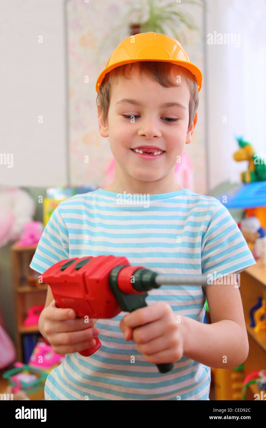 Boy in plastic helmet with toy drill Stock Photo - Alamy