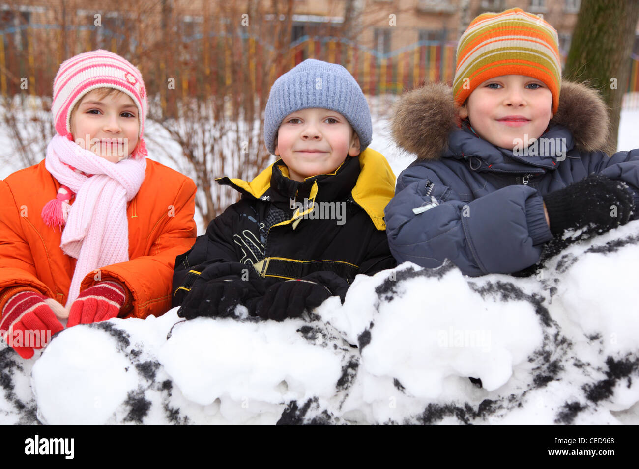 Three children on wall of snow fortress in court yard Stock Photo - Alamy