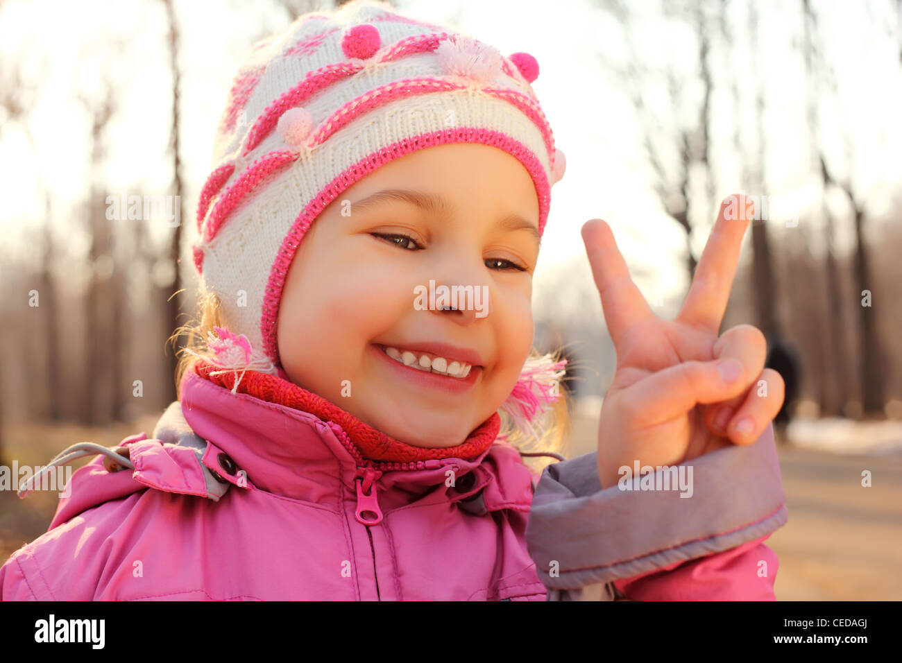 Little girl outdoor shows victory sign Stock Photo - Alamy
