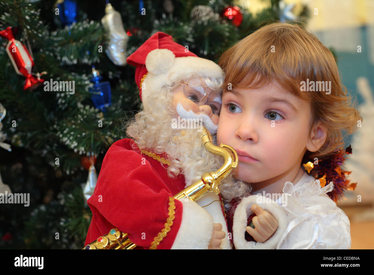 Little girl with toy Father Frost under New Year`s tree Stock Photo - Alamy