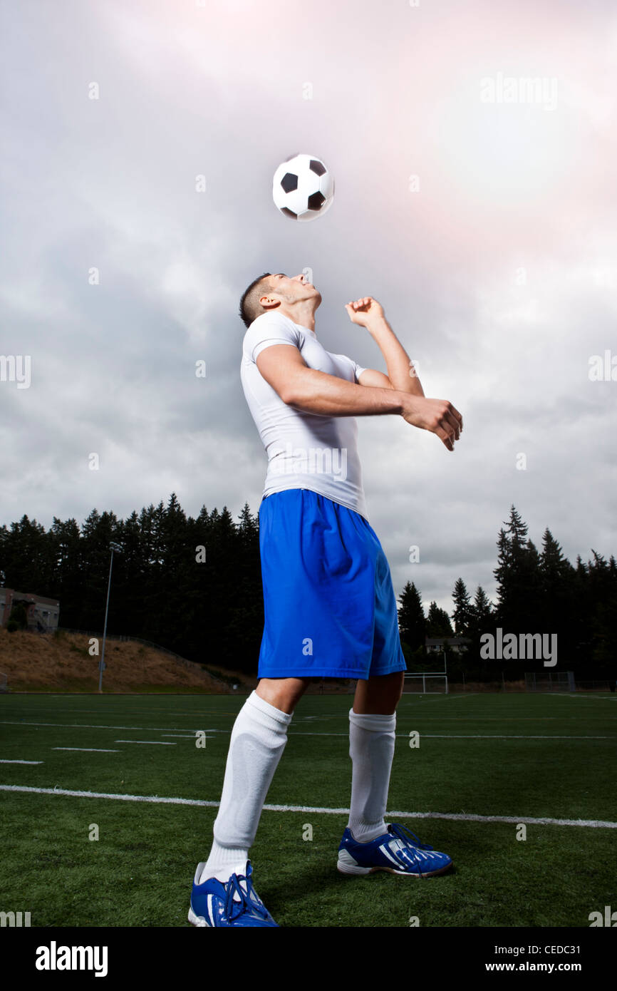 Hispanic athlete heading soccer ball Stock Photo - Alamy