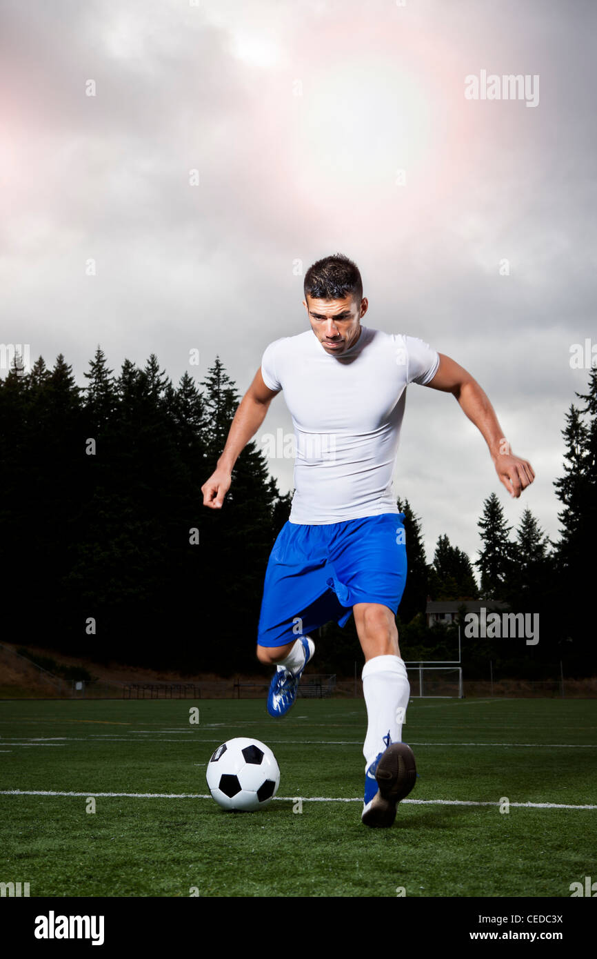 Hispanic athlete kicking soccer ball Stock Photo - Alamy