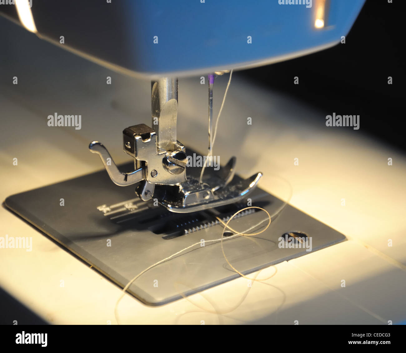 Sewing machine mechanism needle and thread in ambient light Stock Photo ...