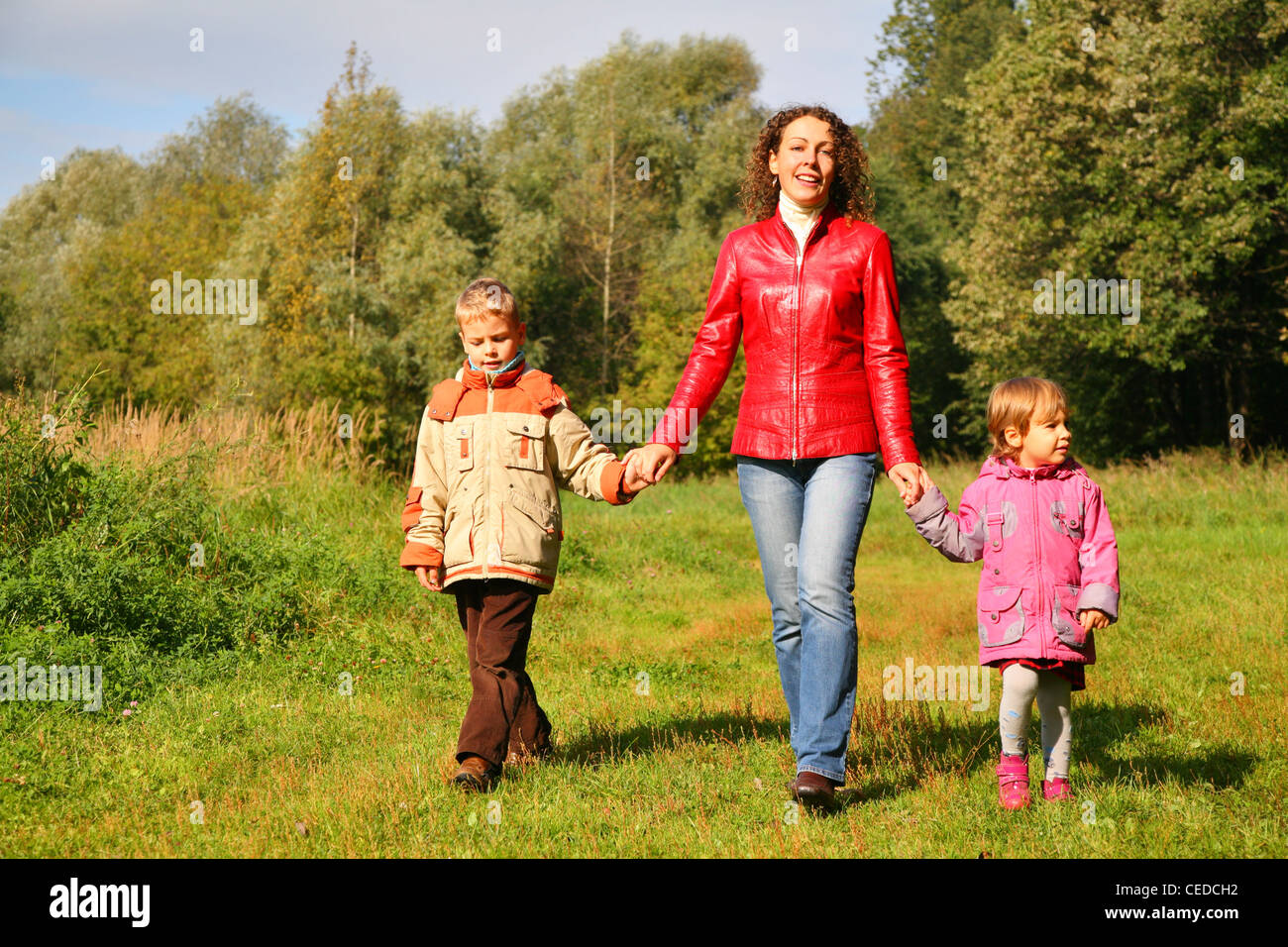 Mother with children on walk in wood, front view Stock Photo - Alamy