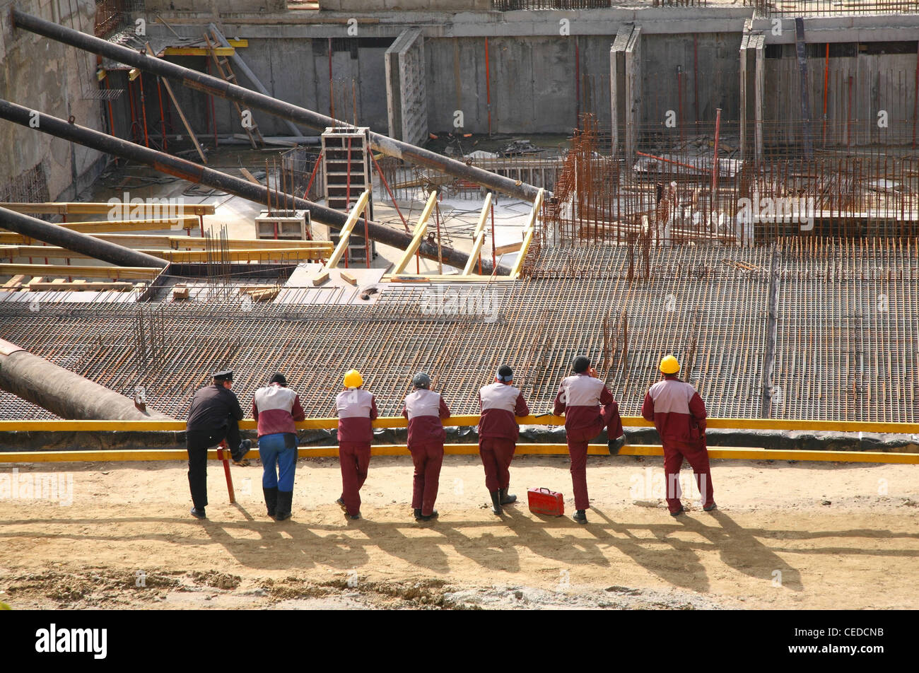 Workers look at building, rear view Stock Photo - Alamy