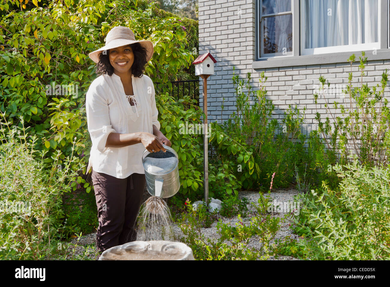 African women watering plants hi-res stock photography and images - Alamy