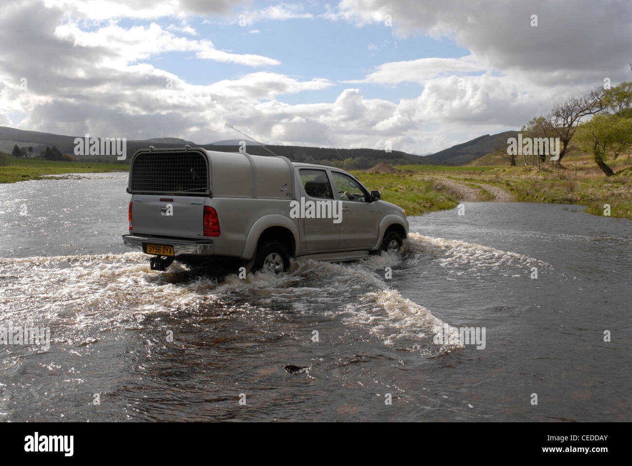 Four Wheeled drive vehicle driving through the River Oykel, Sutherland ...