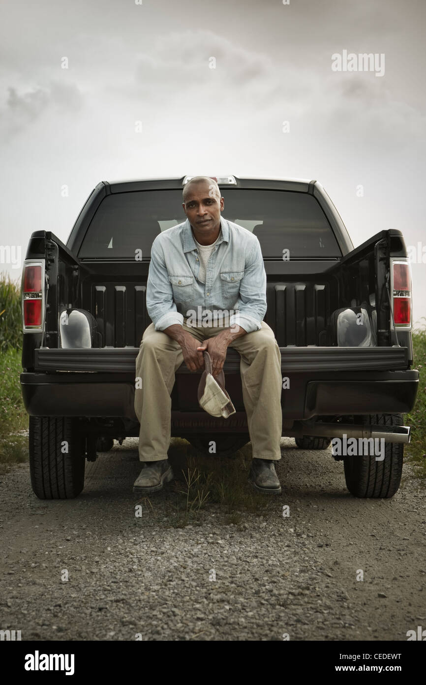 African American sitting on back of pick-up truck Stock Photo - Alamy