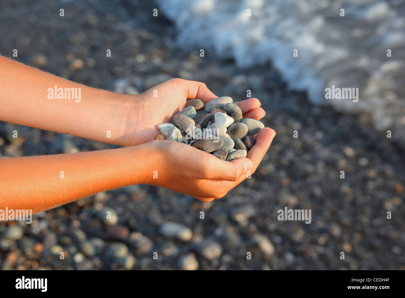 Handful of stones in hands Stock Photo - Alamy