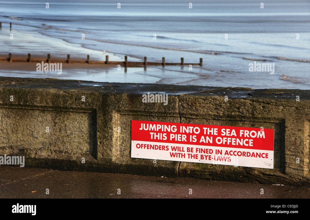 Safety sign on sea wall in dangerous area Stock Photo - Alamy