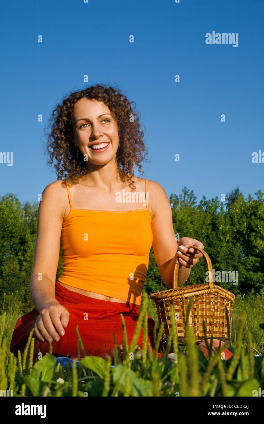 Young Women with basket on glade Stock Photo - Alamy
