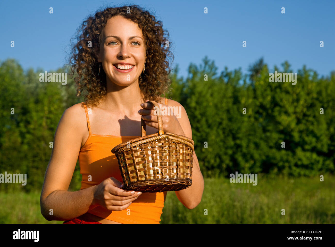 Young Women with basket on glade Stock Photo - Alamy